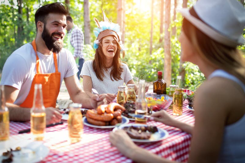Group of Happy Friends Eating and Drinking Beers at Barbecue Dinner ...