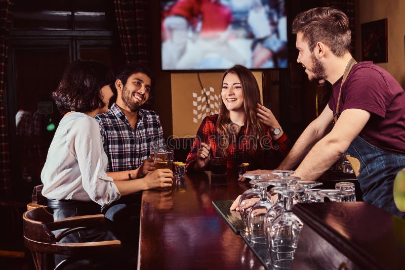 Group of Happy Multiracial Friends Resting at Bar and Talking with the ...