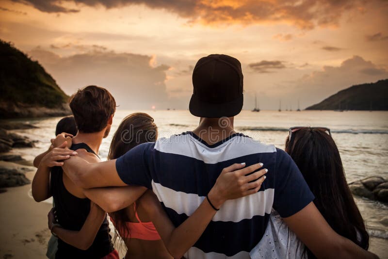Friends on beach at sunset stock photo. Image of happy - 114480418