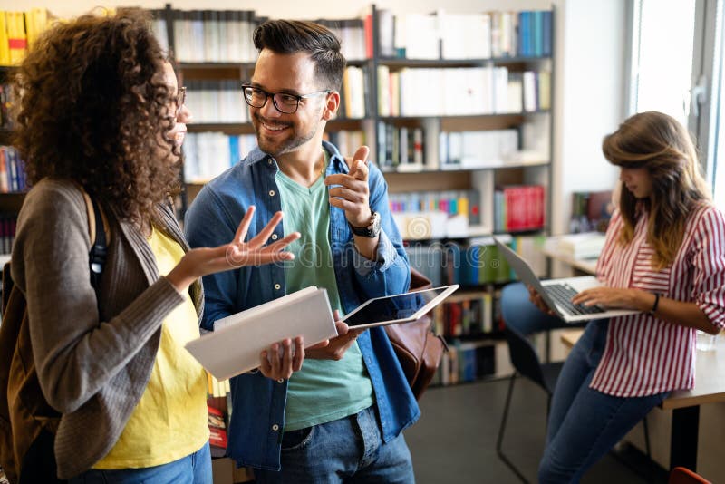 Group of Happy Students Reading Books and Preparing To Exam in Library ...