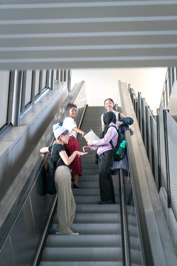 Group of Happy Young Female Students Going Up the Escalator Stock Photo ...