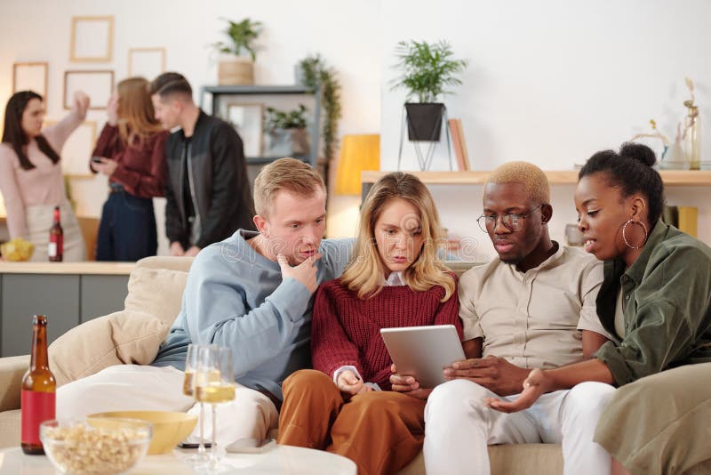 Group of Happy Young Intercultural Friends Discussing Photos in Social ... Group of Happy Young Intercultural Friends Discussing Photos in Social ...