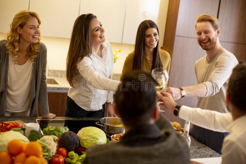 Group of Young People Preparing Meal, Drinking White Wine and Having a ...