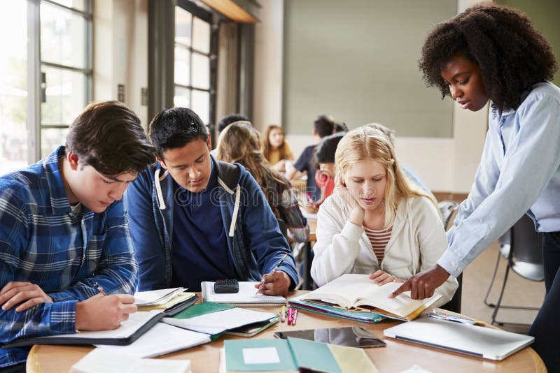 Group of High School Students with Female Teacher Working at Desk Stock ...