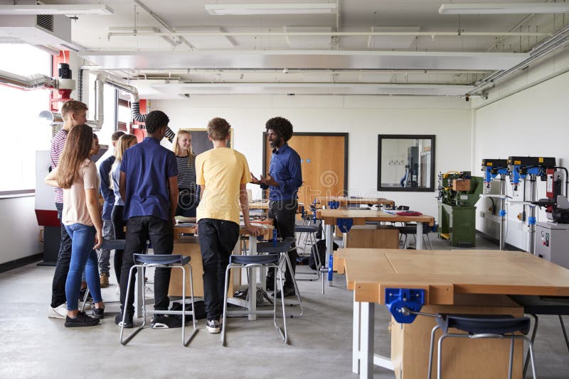 Group of High School Students Standing Around Work Bench Listening To ...