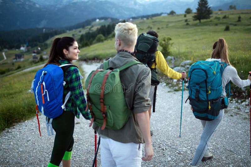 Group of Hikers with Backpacks and Sticks Walking on Mountain. Friends ...