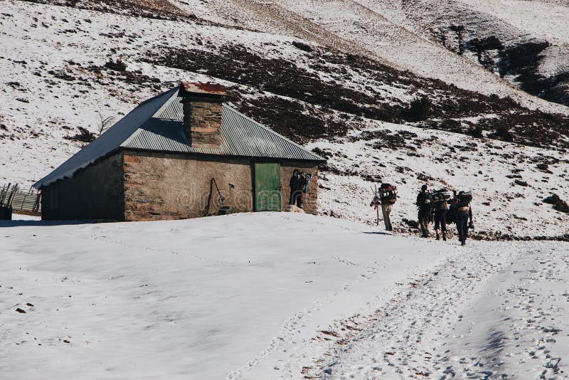 Group of Hikers Near the Old Building on the Mountain Covered with Snow ...