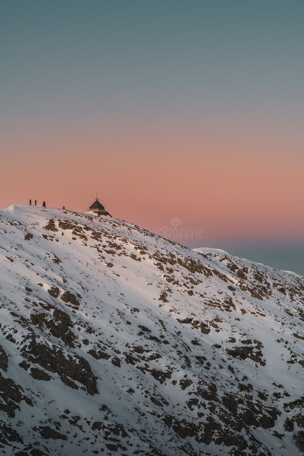 People Walking Up the Side of a Snowy Mountain during Sunset Stock ...