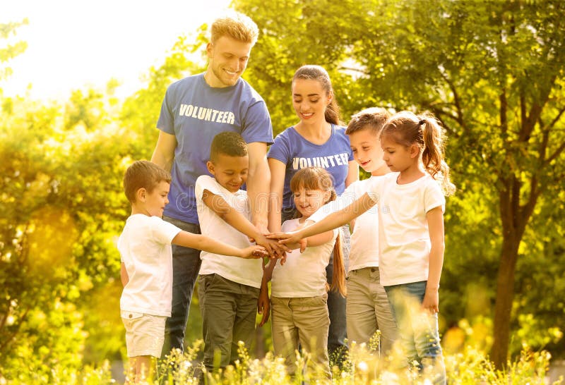 Group of Kids Joining Hands with Volunteers in Park Stock Image - Image ...