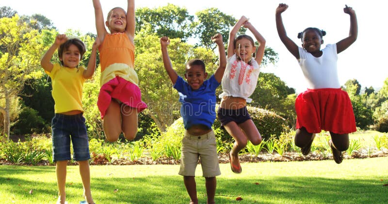 Group of Kids Jumping Together in Park Stock Video - Video of green ...