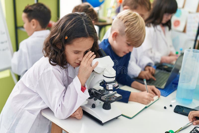Group of Kids Students Using Microscope Writing on Notebook at ...