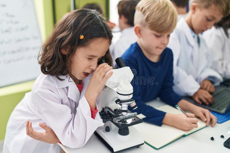 Group of Kids Students Using Microscope Writing on Notebook at ...