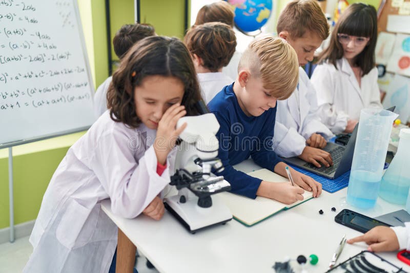Group of Kids Students Using Microscope Writing on Notebook at ...