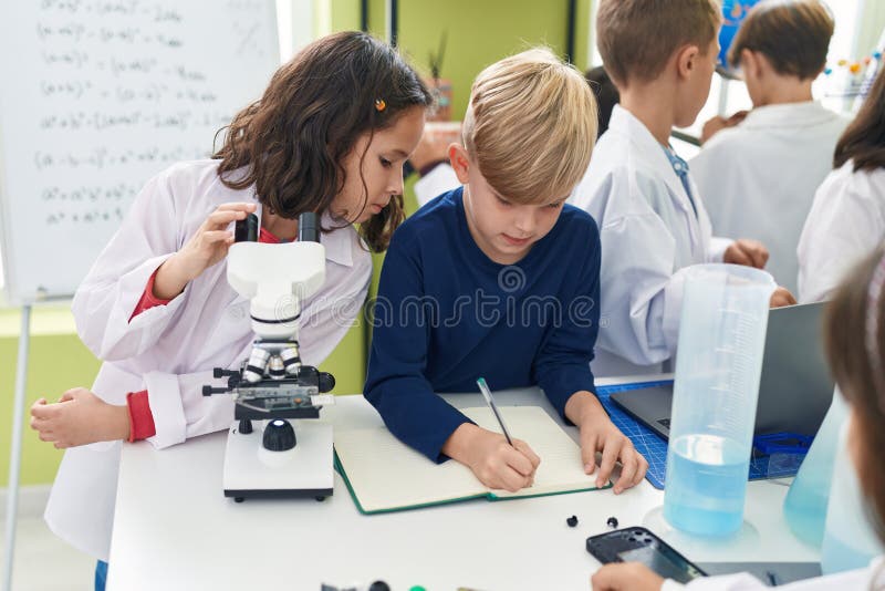 Group of Kids Students Using Microscope Writing on Notebook at ...