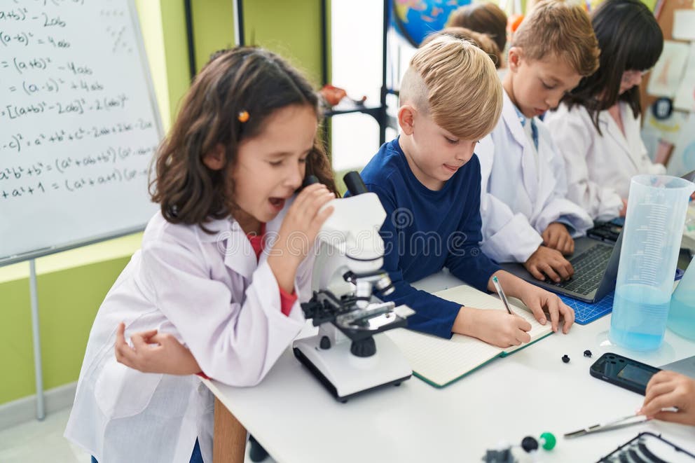 Group of Kids Students Using Microscope Writing on Notebook at ...