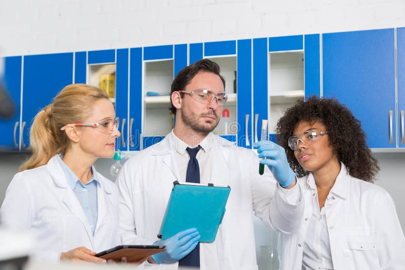 Group of Laboratory Scientists Examining Green Liquid in Test Tube ...