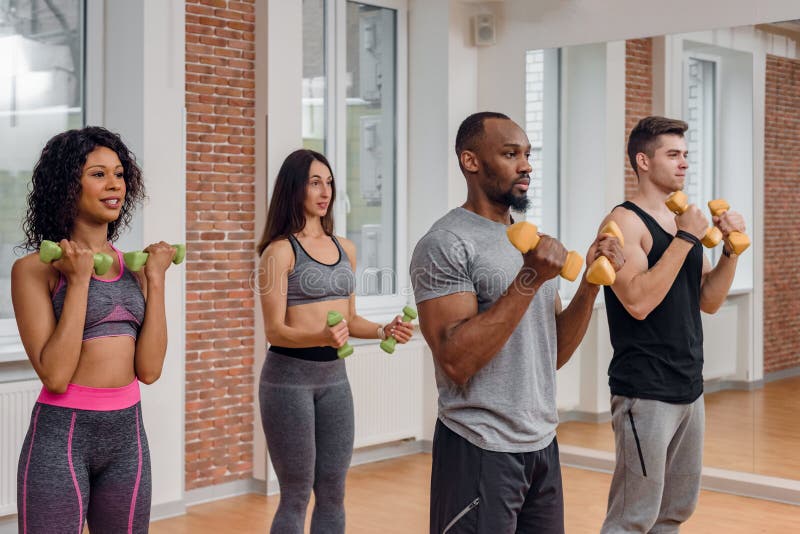 Group lifting dumbbells stock image. Image of figure - 210078383