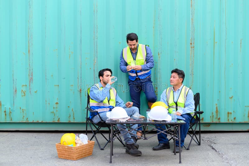 Two Logistic Staff Workers Talk and Rest Sitting in the Shipping Yard ...