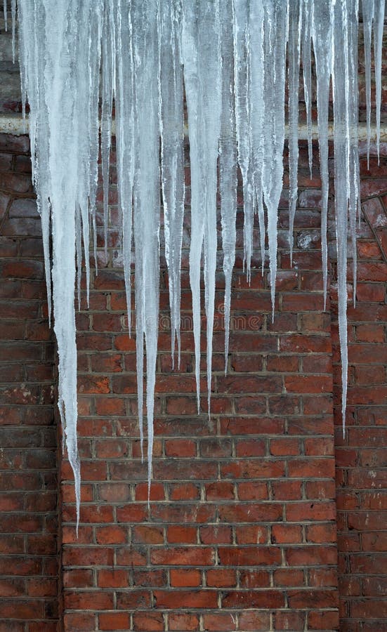 Group of Long Icicles on Brick Wall Background Stock Image - Image of ...