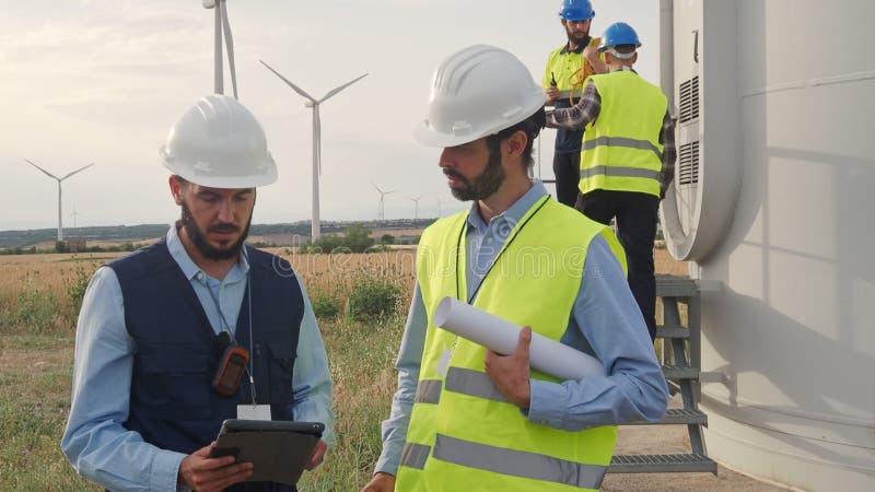 Group of Male Technical Workers and Engineers Watching a Blueprint in a ...