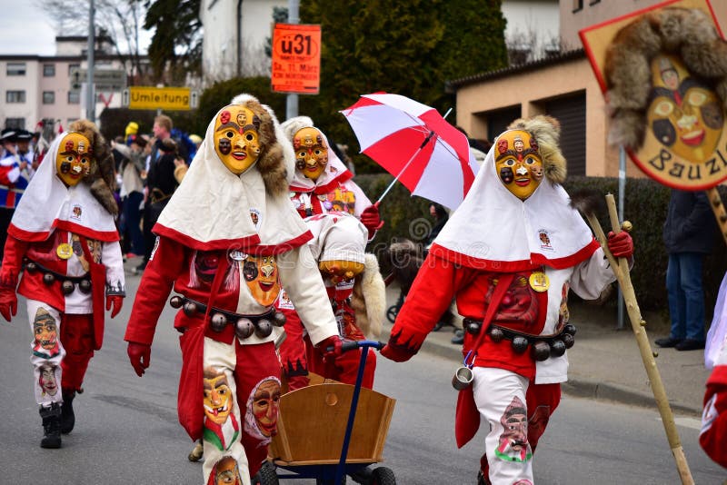 Group of Masked People Garbed in Red and White Jester Attire Parading ...