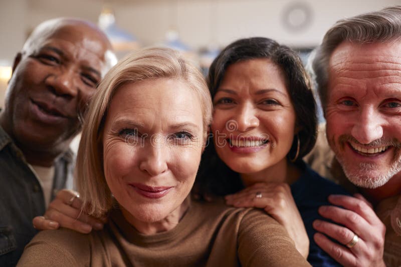 Group of Mature Friends Posing for Selfie on Mobile Phone at Home Stock ...
