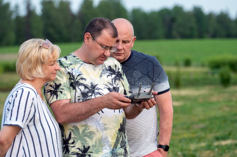 Group of Mature People Watching Drone Remote Control Screen in Park ...