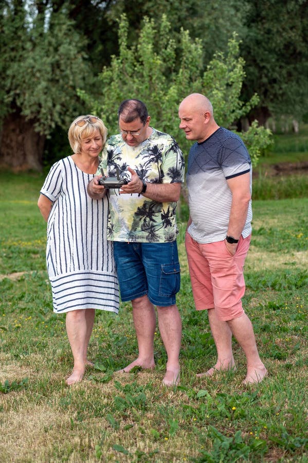 Group of Mature People Watching Drone Remote Control Screen in Park ...