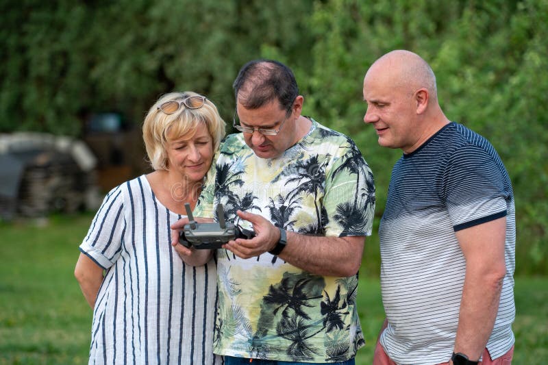 Group of Mature People Watching Drone Remote Control Screen in Park ...