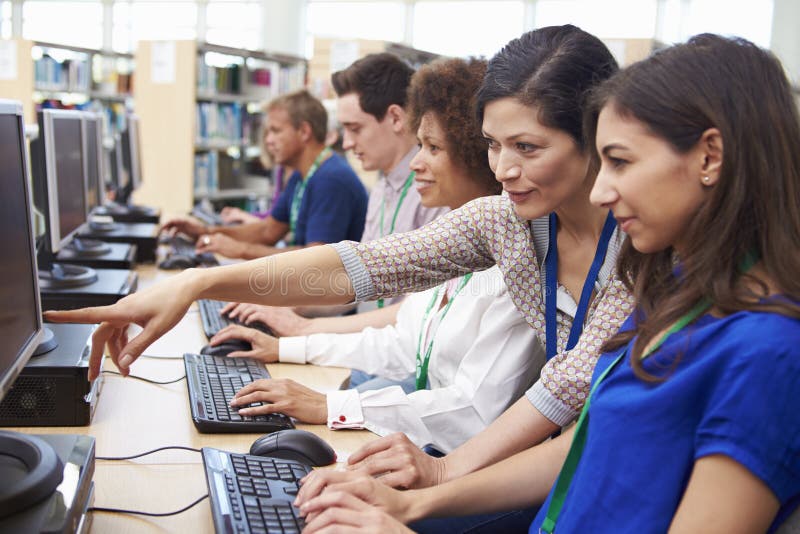 Group of Mature Students Working at Computers with Tutor Stock Image ...