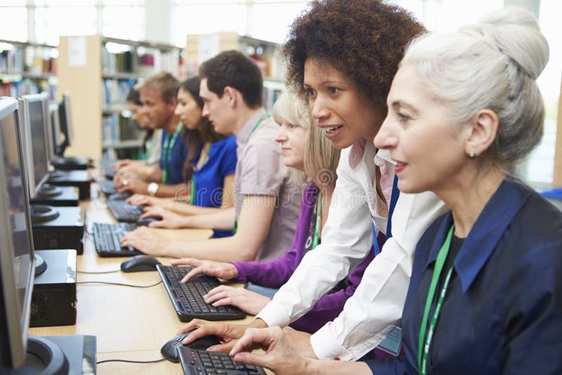 Group of Mature Students Working at Computers with Tutor Stock Image ...