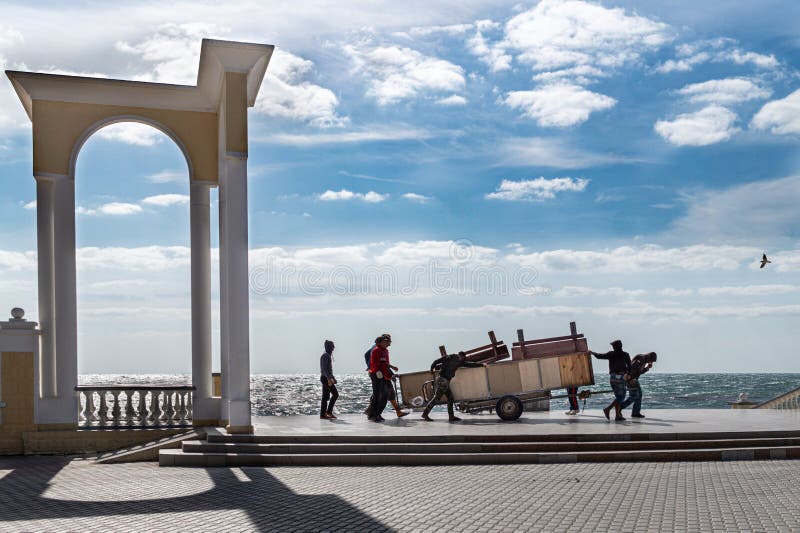 A Group of Men Drag a Heavy Wagon Along the Seafront Editorial ...