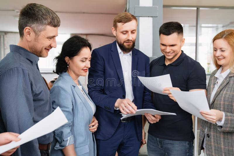 A Group of Men and Women Work with Documents in Coworking. Concept of ...