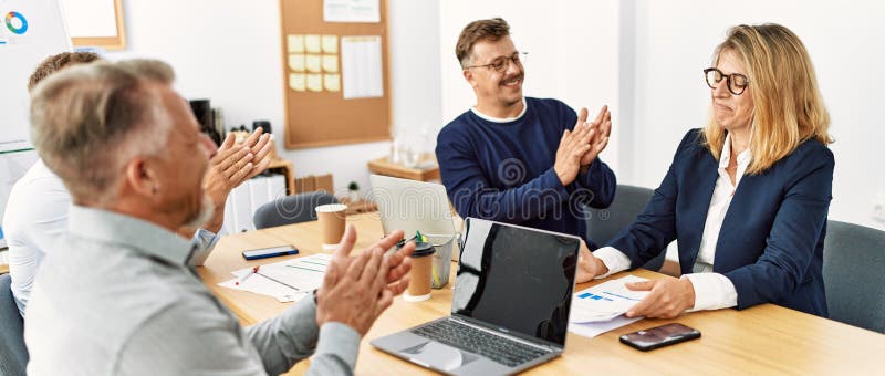Group of Middle Age Business Workers Smiling and Clapping To Partner at ...