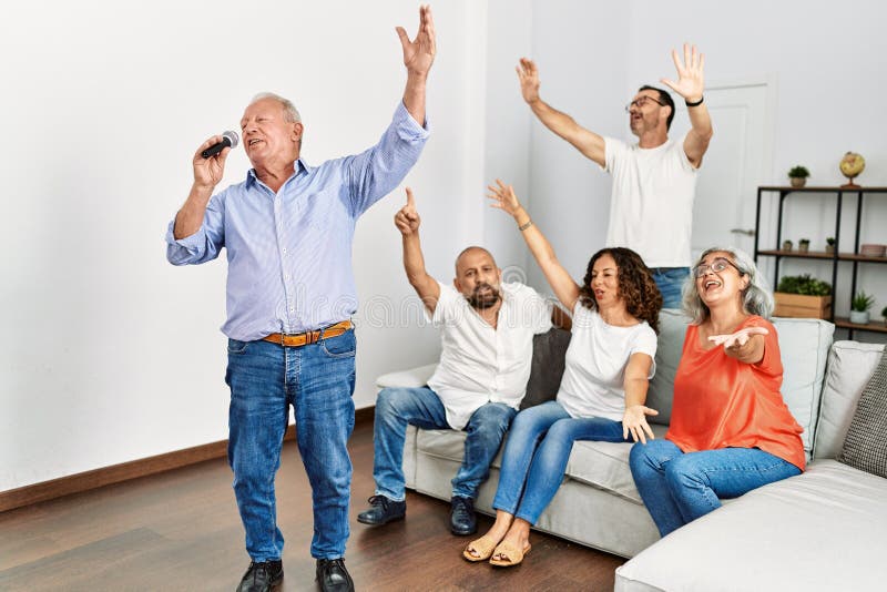 Group of Middle Age Friends Having Party Singing Song Using Microphone ... Group of Middle Age Friends Having Party Singing Song Using Microphone ...