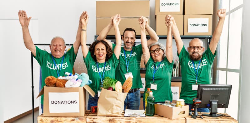 Group of Middle Age Volunteers Smiling Happy with Hands Together Raised ... Group of Middle Age Volunteers Smiling Happy with Hands Together Raised ...