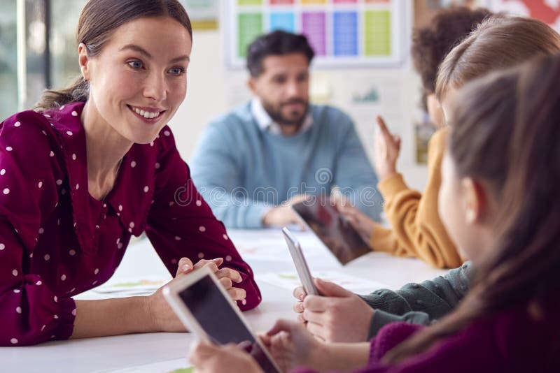 Group of Multi-Cultural Students with Teachers in Classroom Using ...