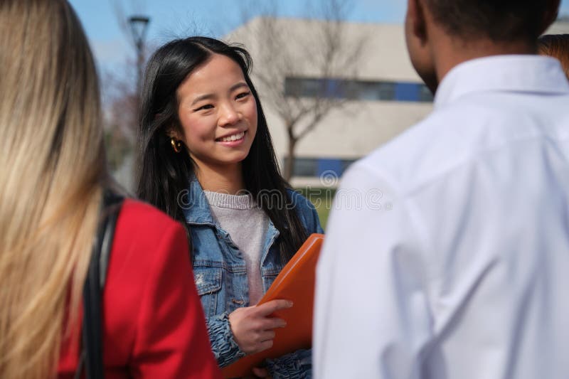 Young Student Smiling and Talking with Colleagues at University Campus ...