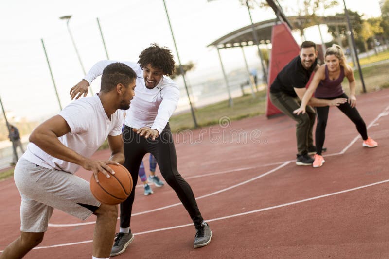 Group of Multiracial Young People Playing Basketball Outdoors Stock ...