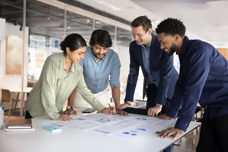 Group of Multiethnic People Reviewing Documents Gathered Around Table Stock Image - Image of ...