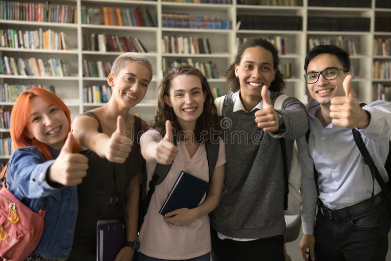 Group of Multiethnic Students Poses in Library Showing Thumbs-up ...