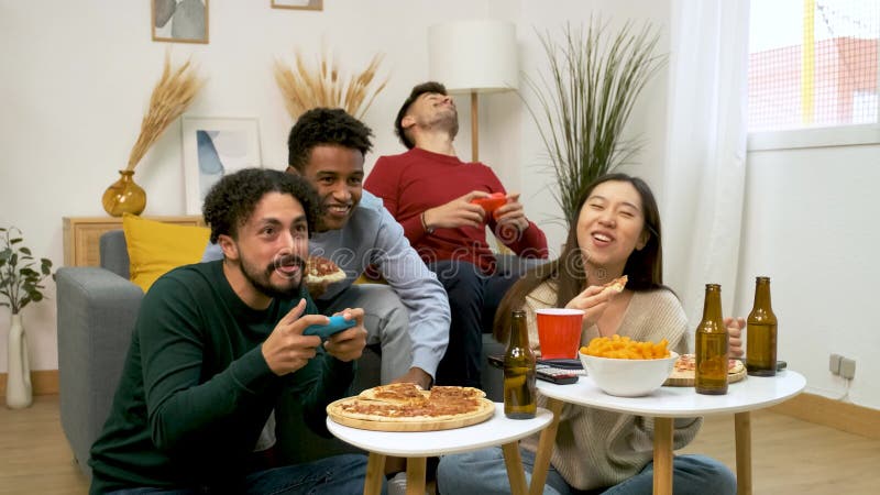 Group of Multiracial Friends Eating Pizza and Playing Video Games ...