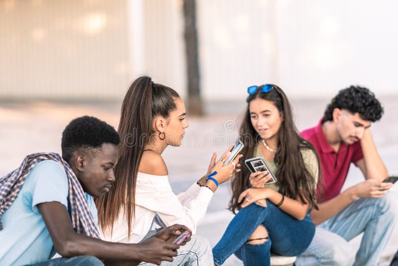 Group of Multiracial Students Using the Mobile Phone while Sitting ...