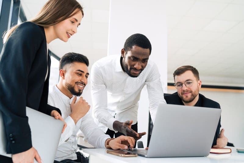 Group of Multiracial White Collar Workers in the Office Behind a Laptop ...