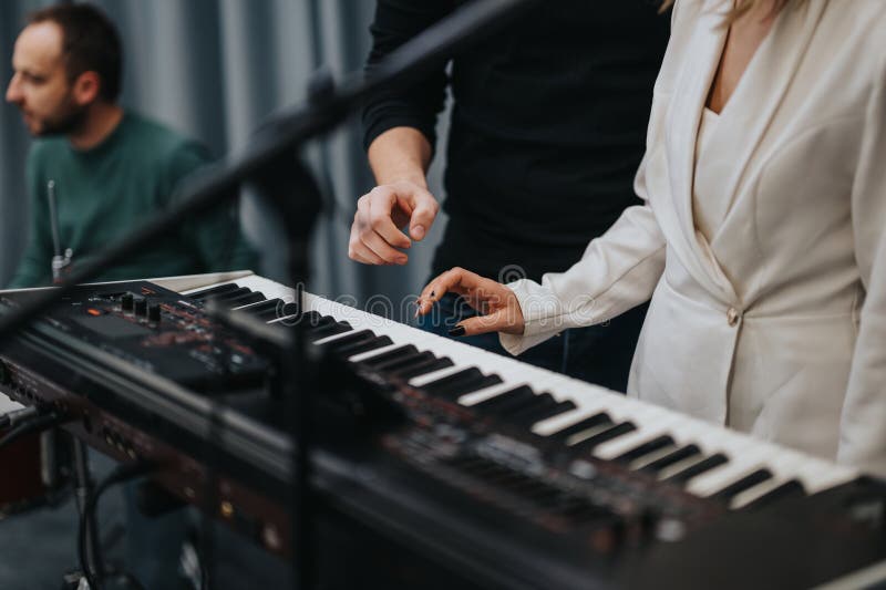 Musicians Rehearsing in a Studio Playing Keyboards and Collaborating ...