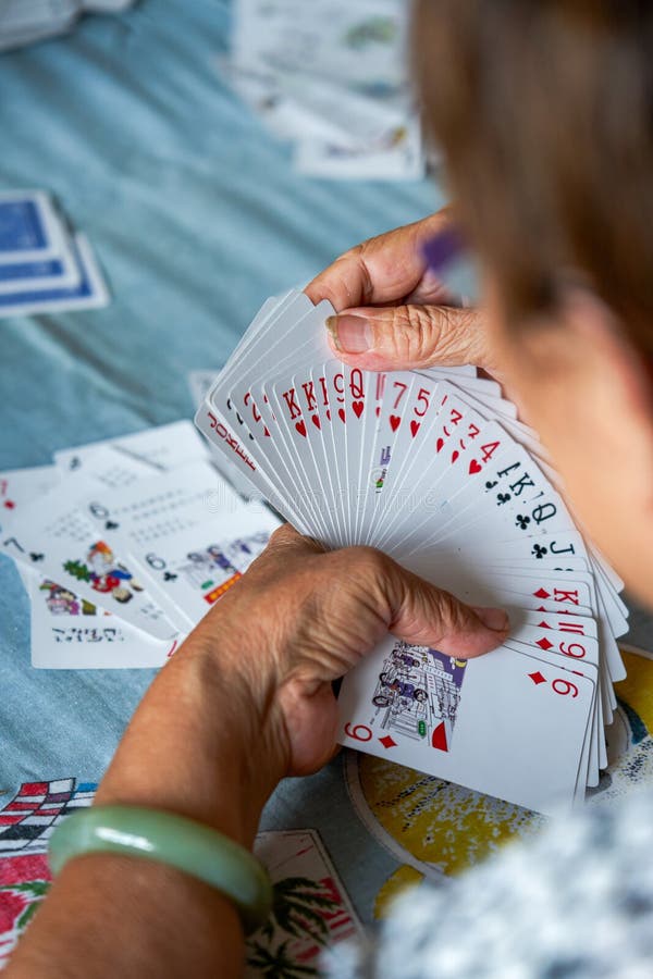 A Group of Old People Sit Around and Play Poker Card Stock Image ...