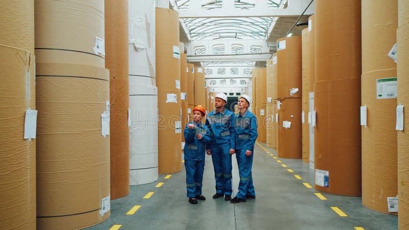 A Group of Paper Mill Workers Engineers Take Inventory of a Huge ...