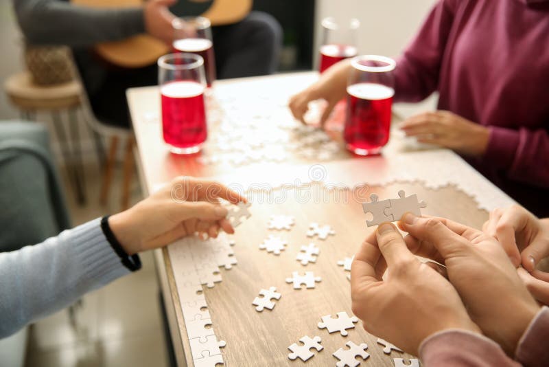 Group of People Assembling Puzzle on Wooden Table Stock Image - Image ...