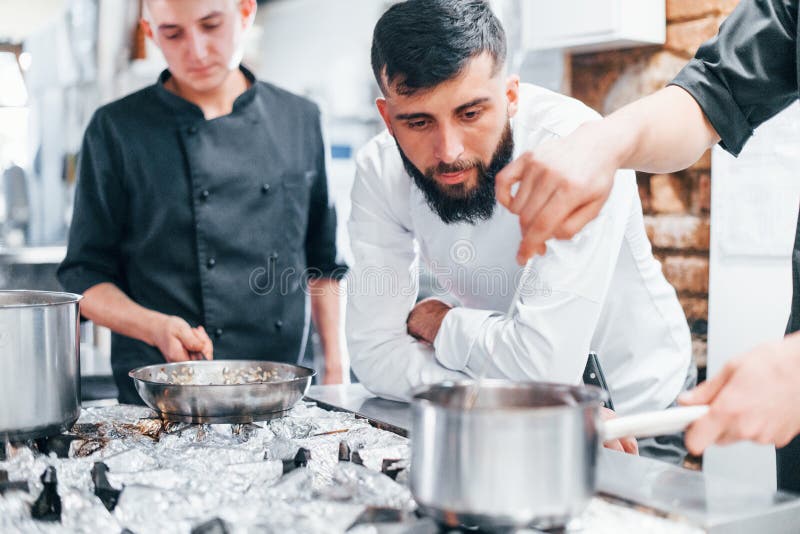 Group of People Cooking Food at Kitchen Together. Busy Day at Work ...