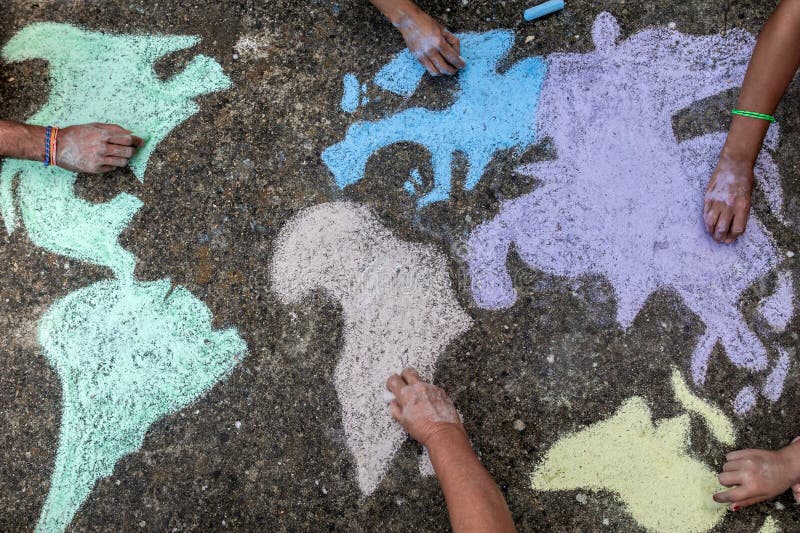 A Group of People Drawing with Colored Chalks on the Floor with His ...